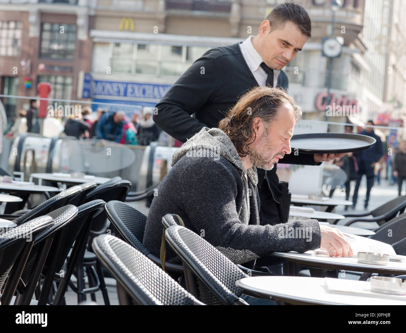 Adult beard man ordering morning coffee in Vienna restaurant. Candid ...