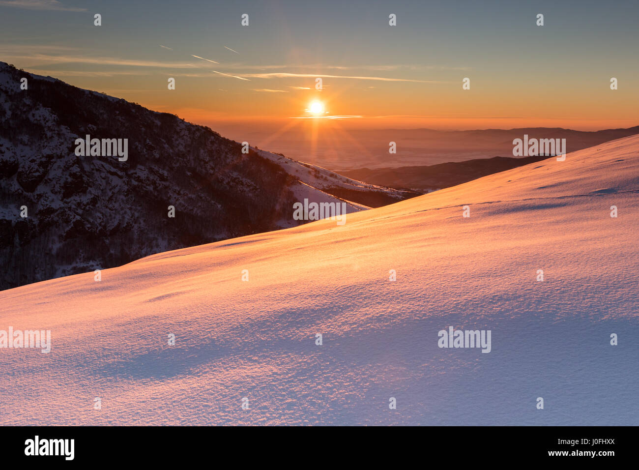 Winter sunrise lightening the snow ridge in red light Stock Photo - Alamy
