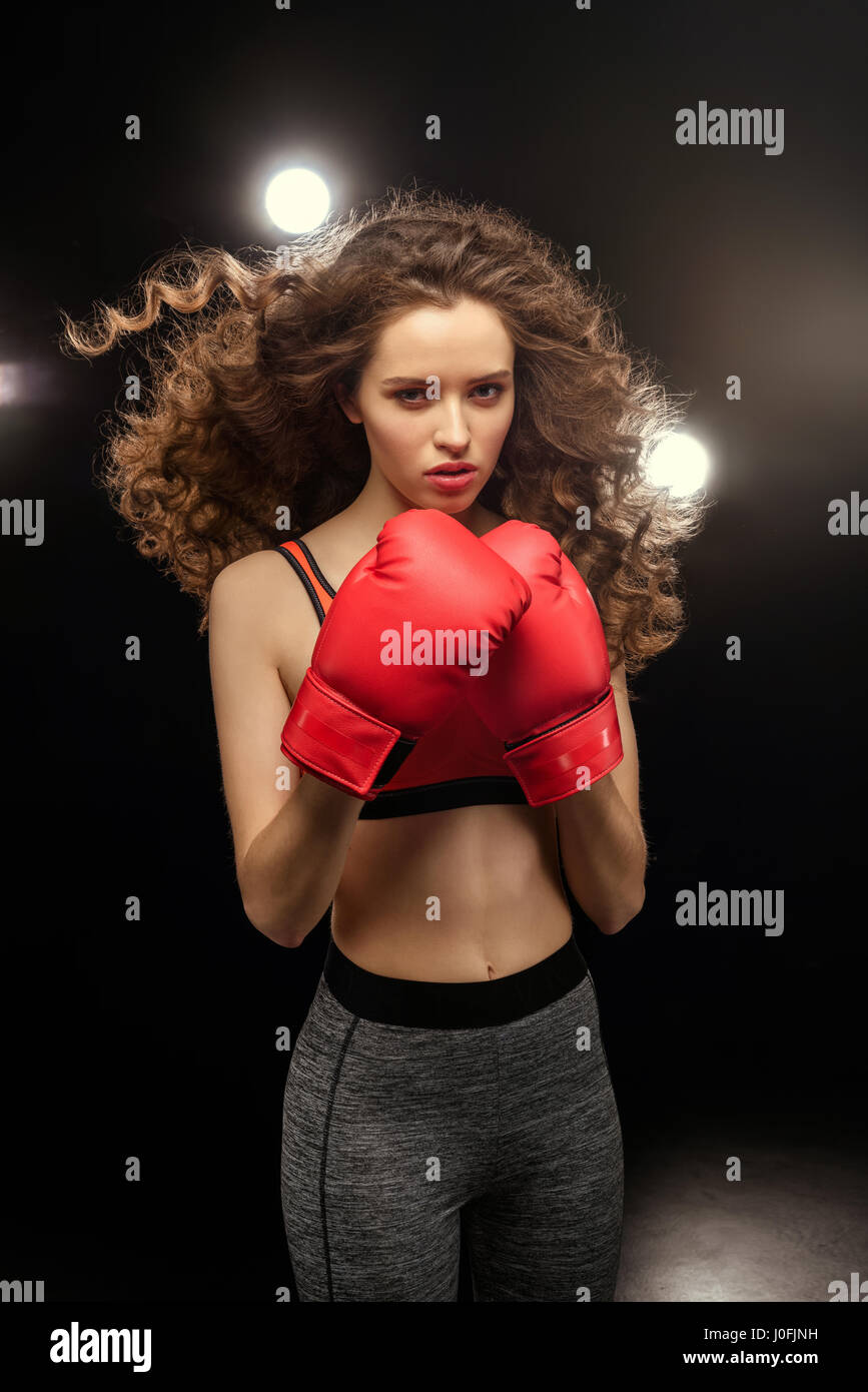 Beautiful young woman boxer in sportswear posing on dark Stock Photo ...
