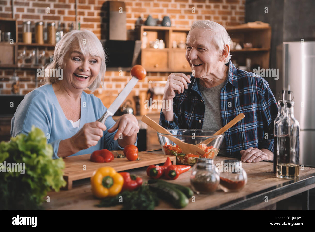 Happy senior couple cooking together and having fun at kitchen Stock ...