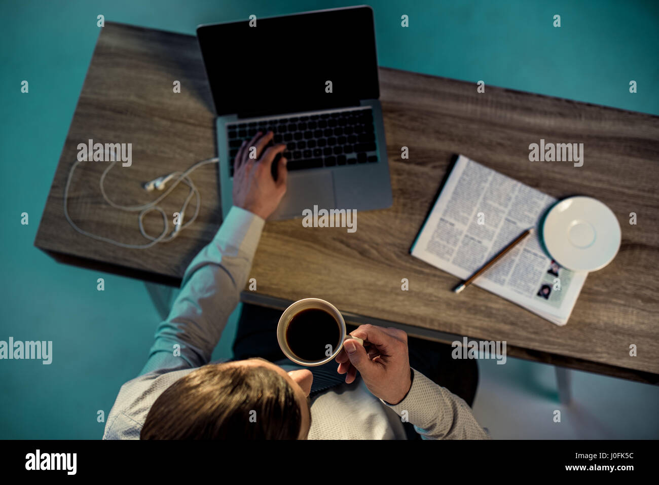 overhead view of man sitting by office table and drinking coffee Stock ...