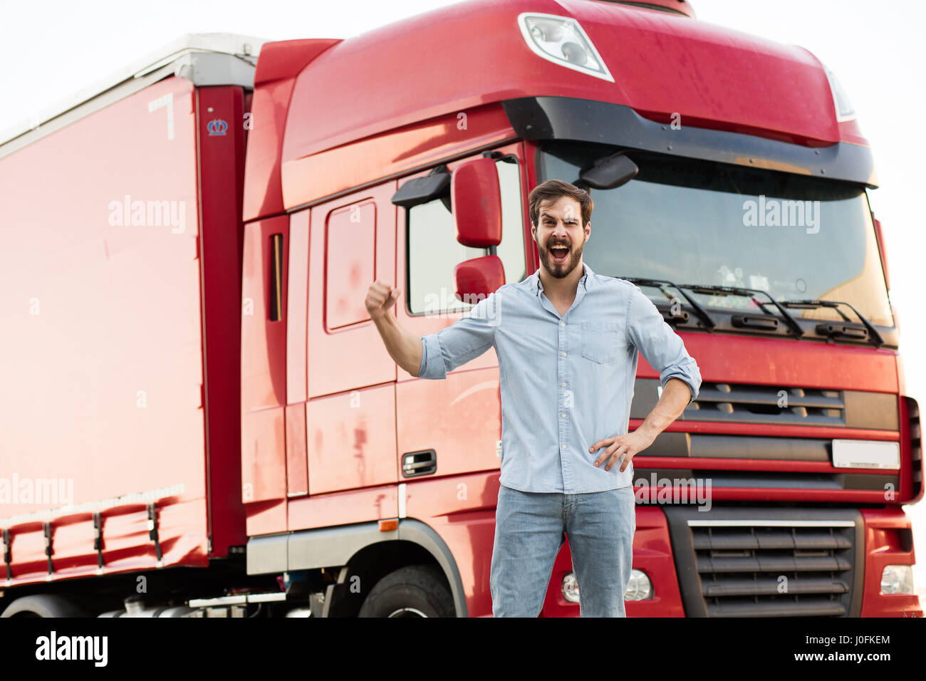 strong masculine truck driver standing outside and showing his muscle ...