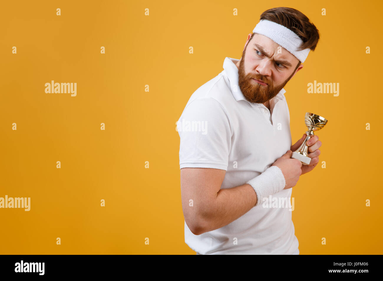 Photo of angry young sportsman with reward dressed in white t-shirt ...