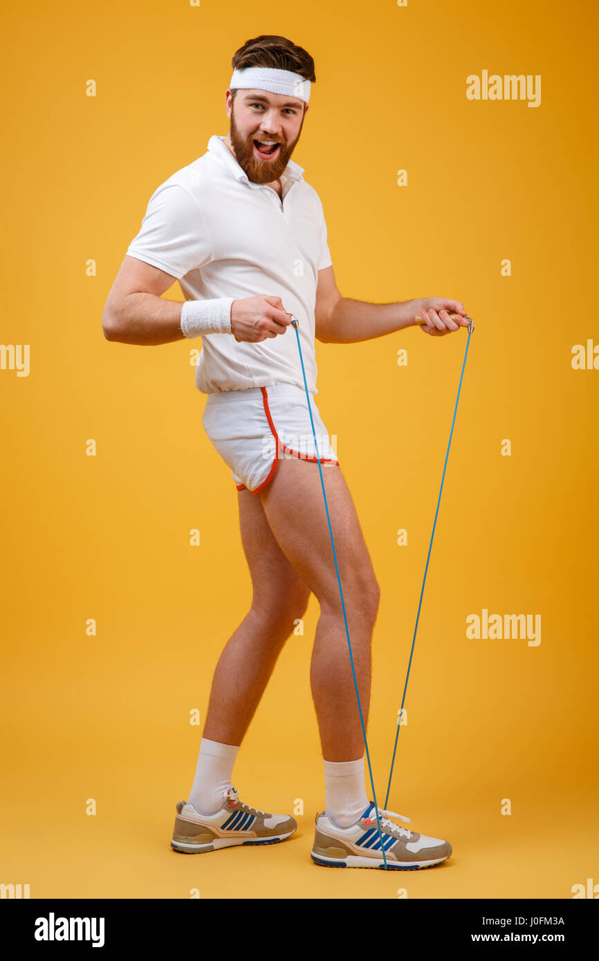 Photo of cheerful young sportsman holding skipping rope dressed in ...