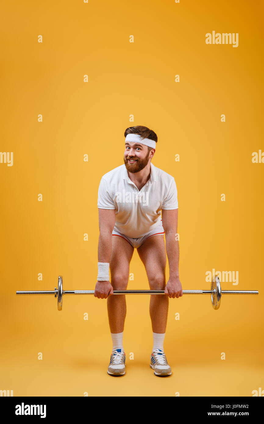 Full length portrait of athletic man doing squatting exercises with ...