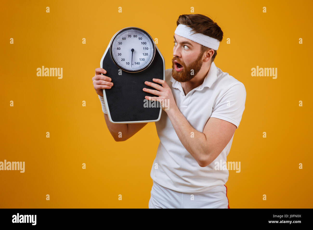 Young man on weighing scales hi-res stock photography and images - Alamy