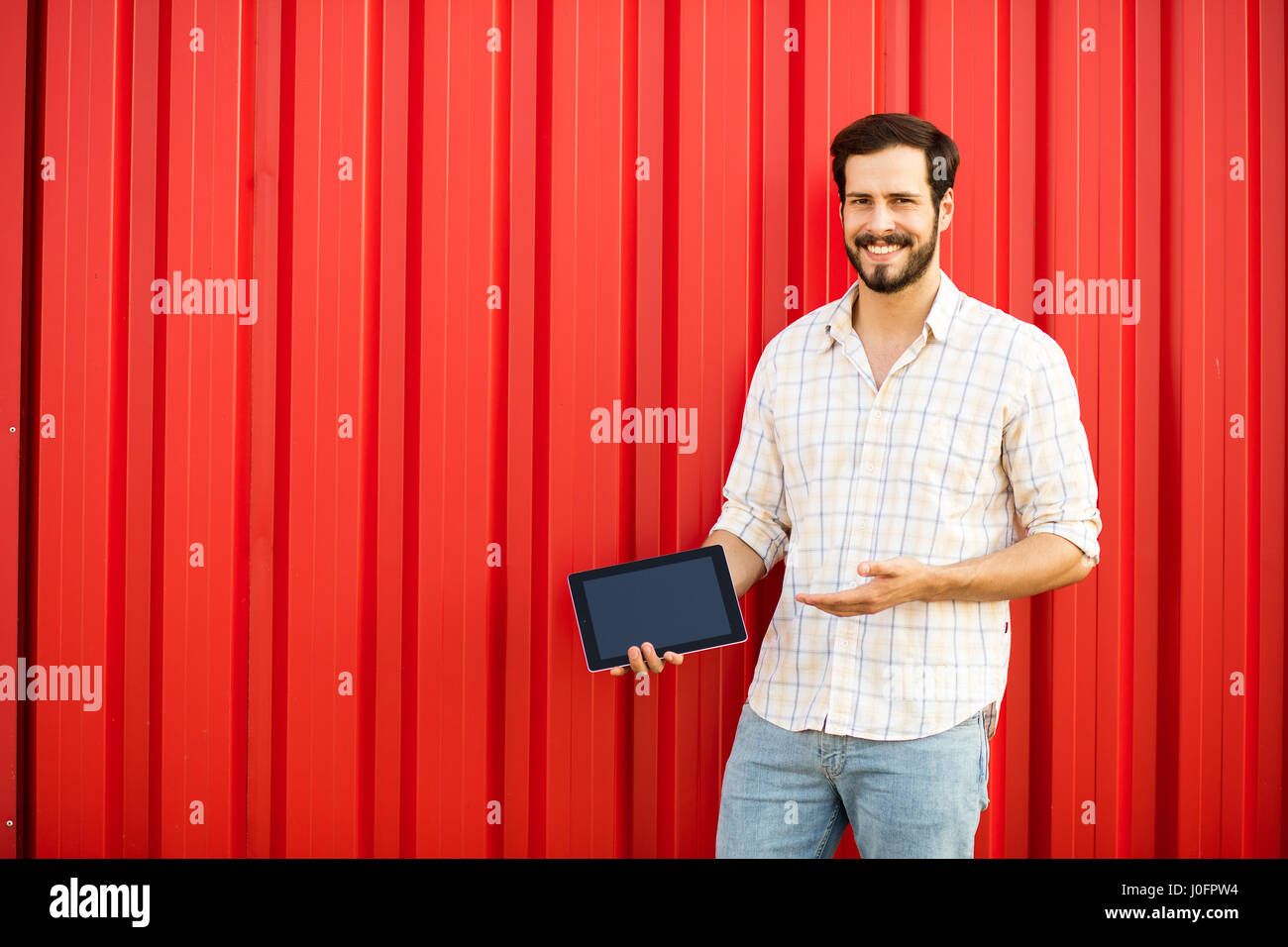smiling attractive man presenting with confidence the screen of his ...