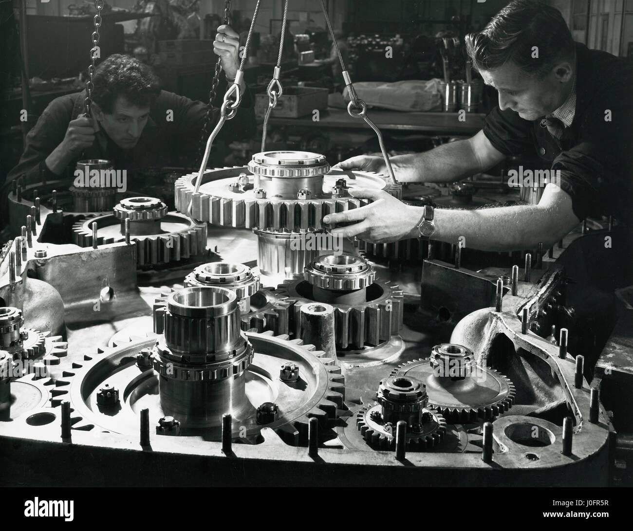 Two fitters assemble the large output pinion into the phasing gear case ...