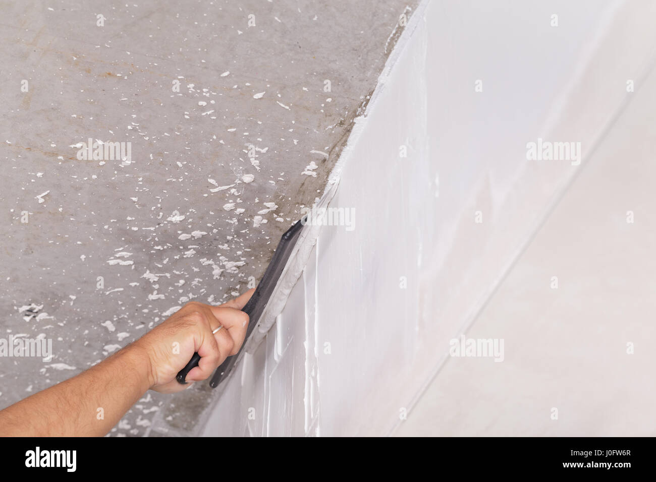house improvement by worker puts finishing layer of stucco on the wall ...