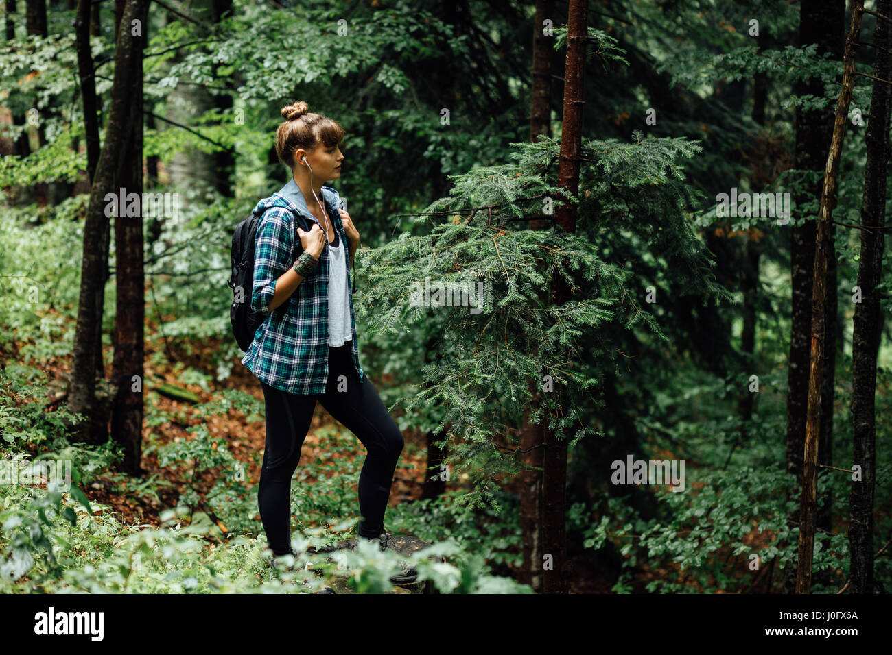 Woman standing among trees hi-res stock photography and images - Alamy