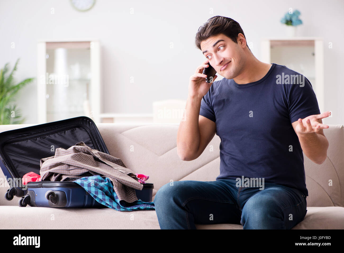 Man going on vacation packing his suitcase Stock Photo - Alamy