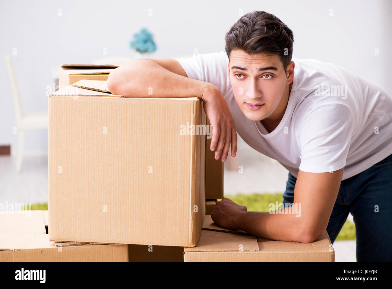 Young man moving boxes at home Stock Photo - Alamy