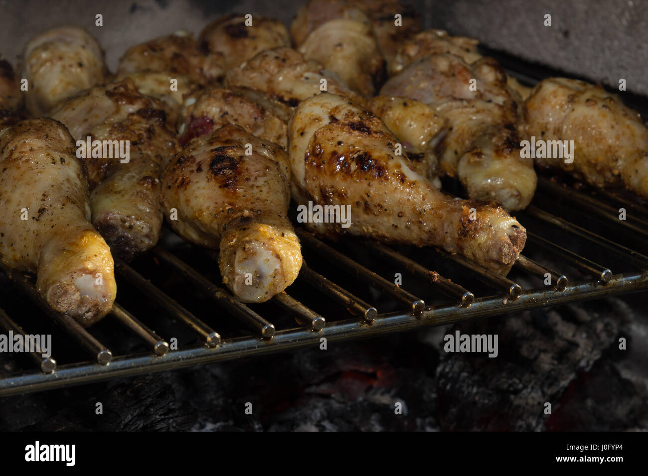 Grilled chicken legs thighs on a grill with a lit fire barbecue Stock ...
