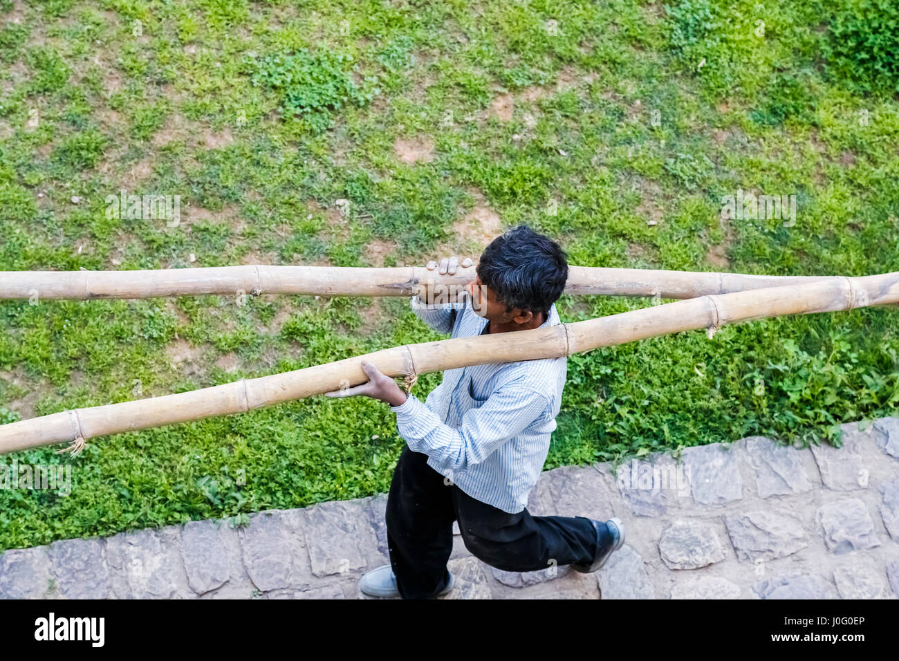 Worker carrying bamboo poles hi-res stock photography and images - Alamy
