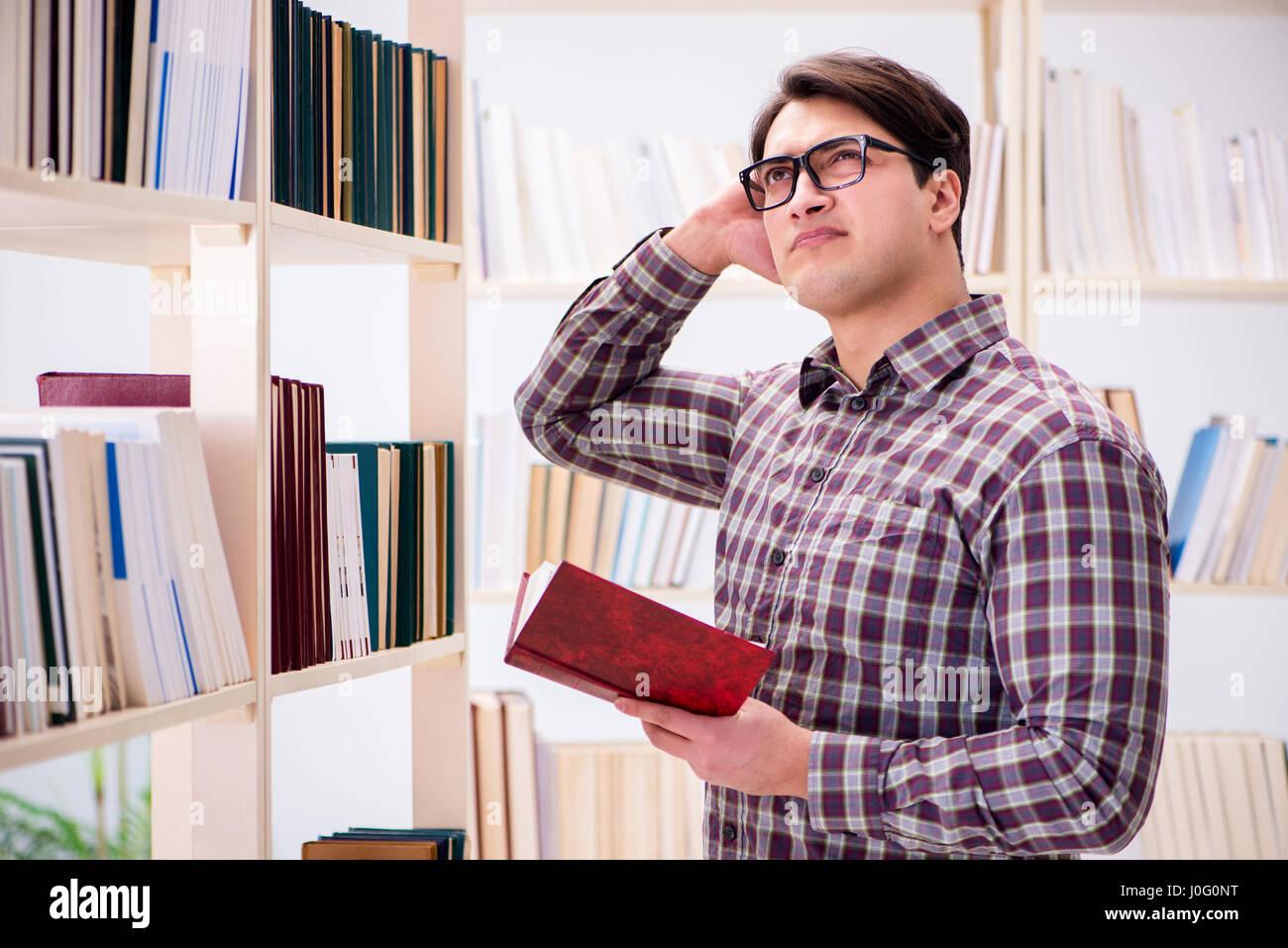 Young student looking for books in college library Stock Photo - Alamy