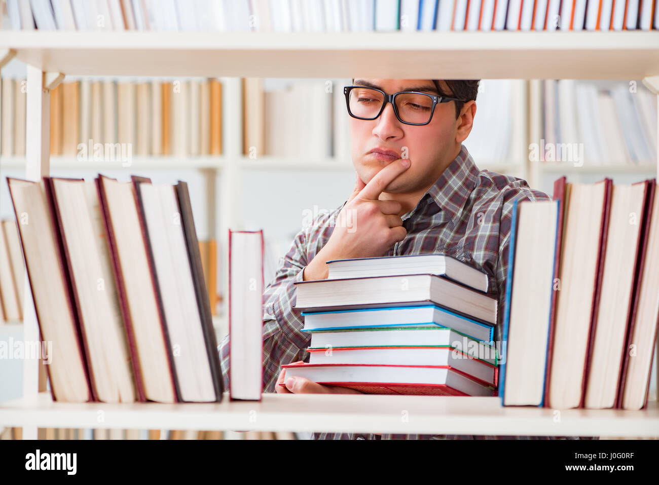 Young student looking for books in college library Stock Photo - Alamy