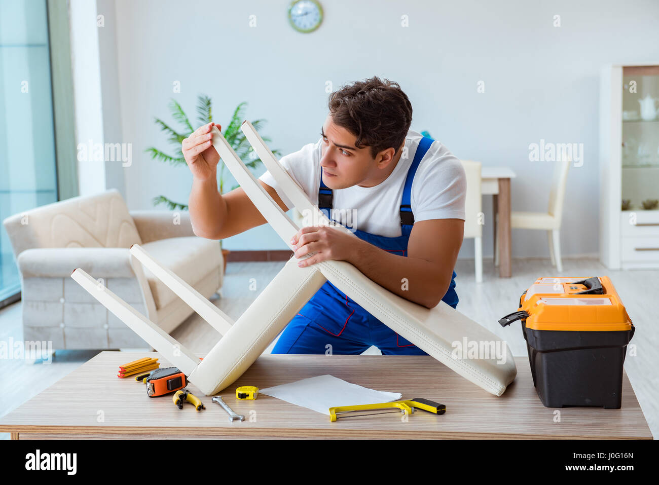 Repairman repairing broken chair at home Stock Photo - Alamy