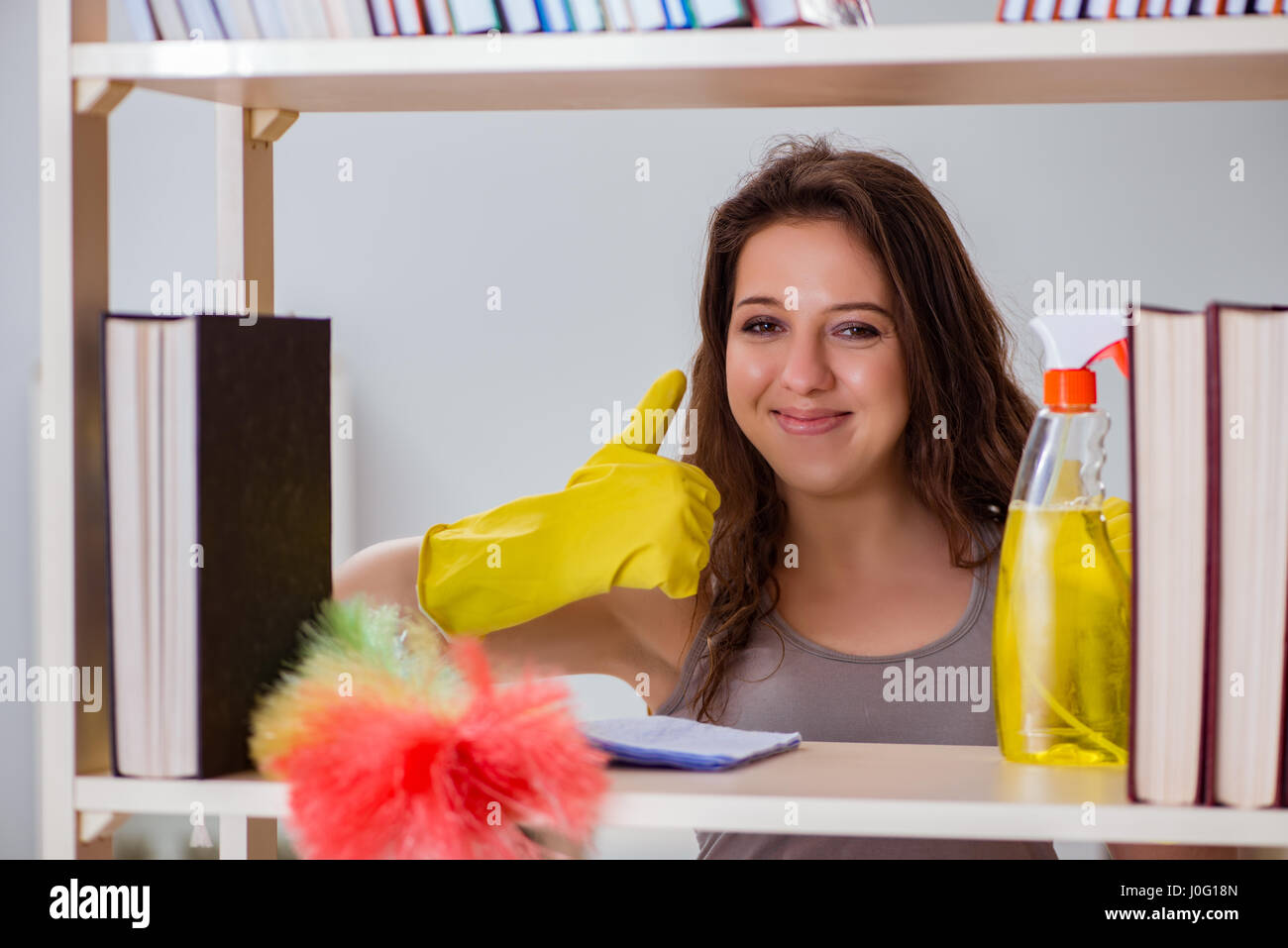 Woman cleaning dust from bookshelf Stock Photo - Alamy