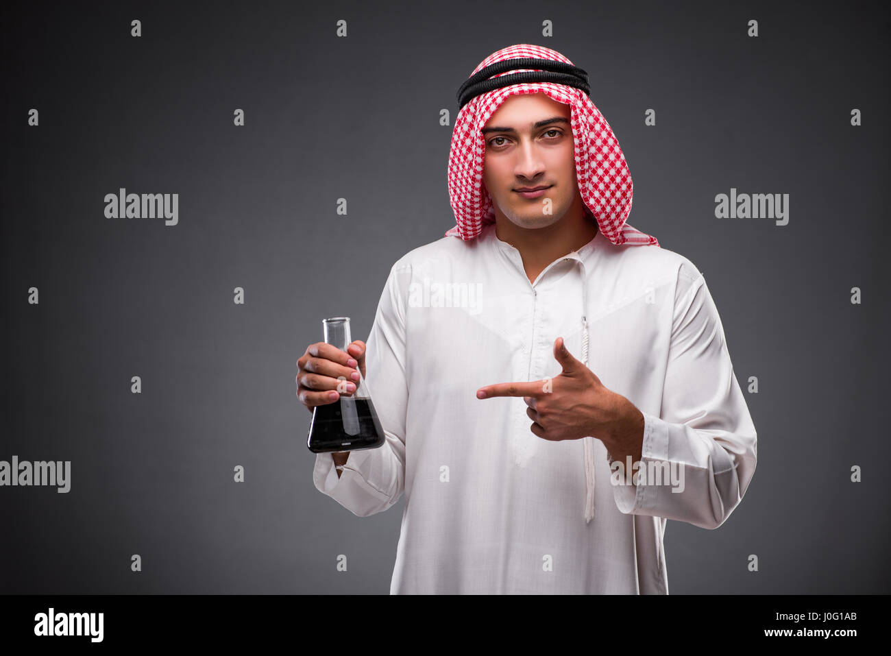 Arab with oil on gray background Stock Photo - Alamy