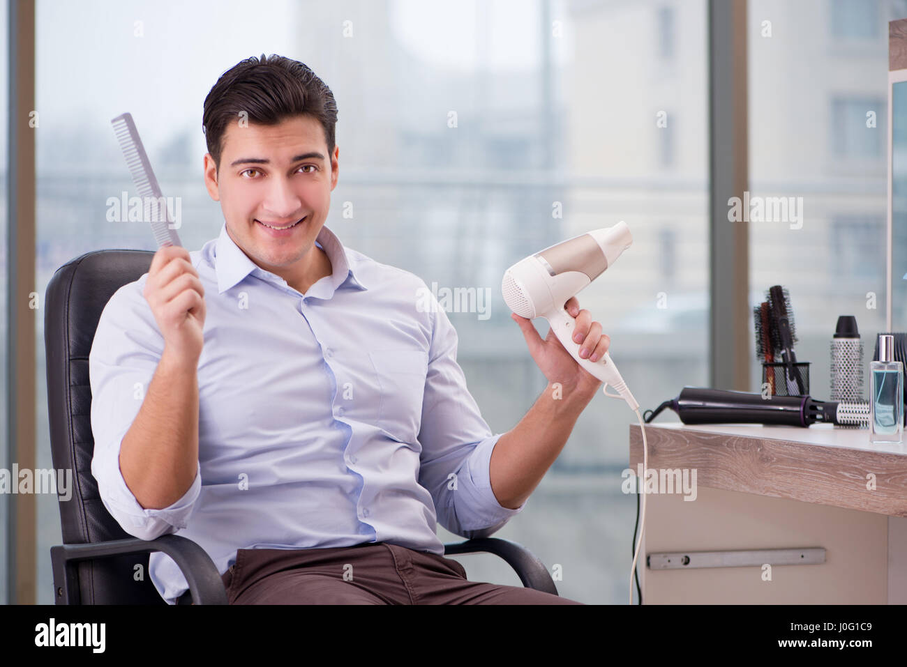 Handsome man in hair salon doing haircut Stock Photo - Alamy