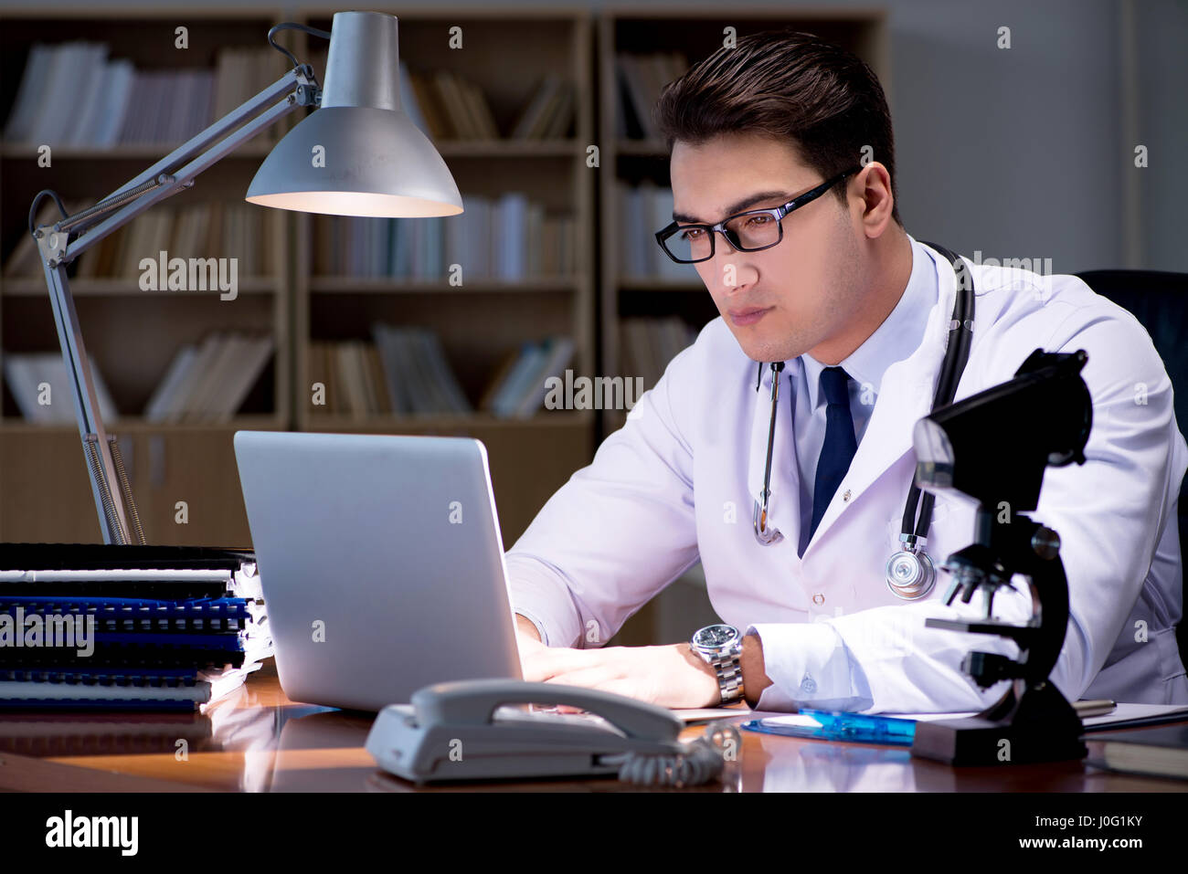 Young doctor working late in the office Stock Photo - Alamy