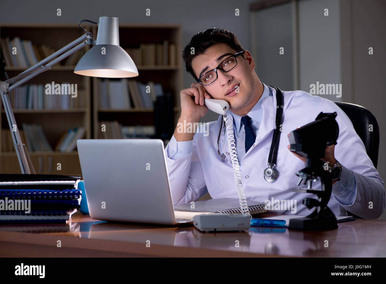 Young doctor working late in the office Stock Photo - Alamy