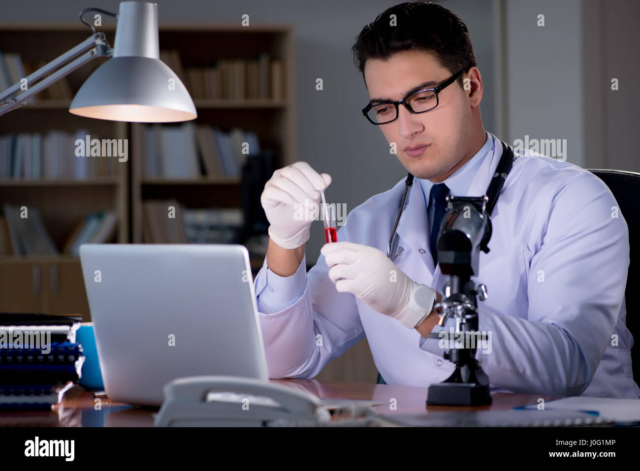Young doctor working late in the office Stock Photo - Alamy