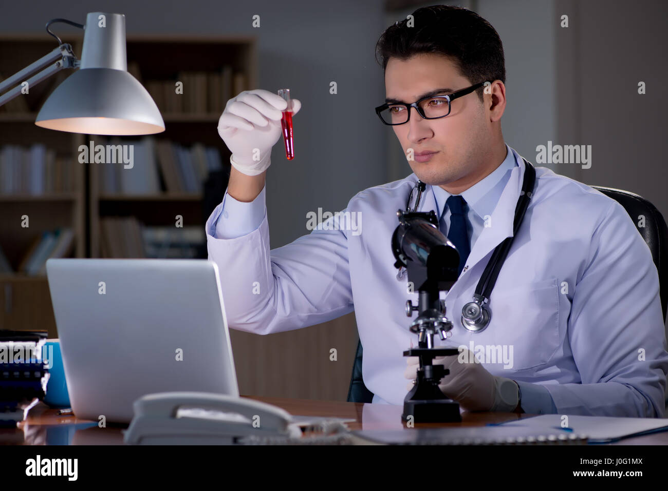 Young doctor working late in the office Stock Photo - Alamy