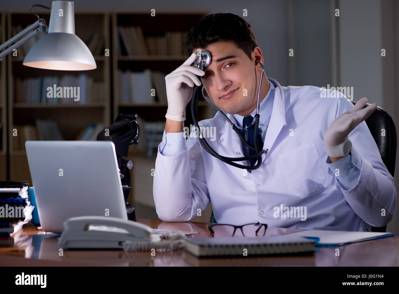 Young doctor working late in the office Stock Photo - Alamy