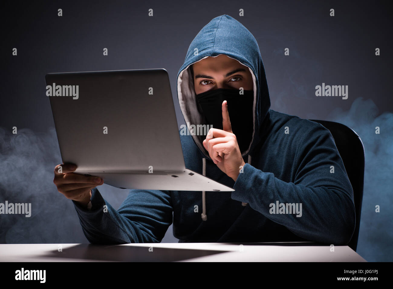 Computer hacker working in dark room Stock Photo - Alamy