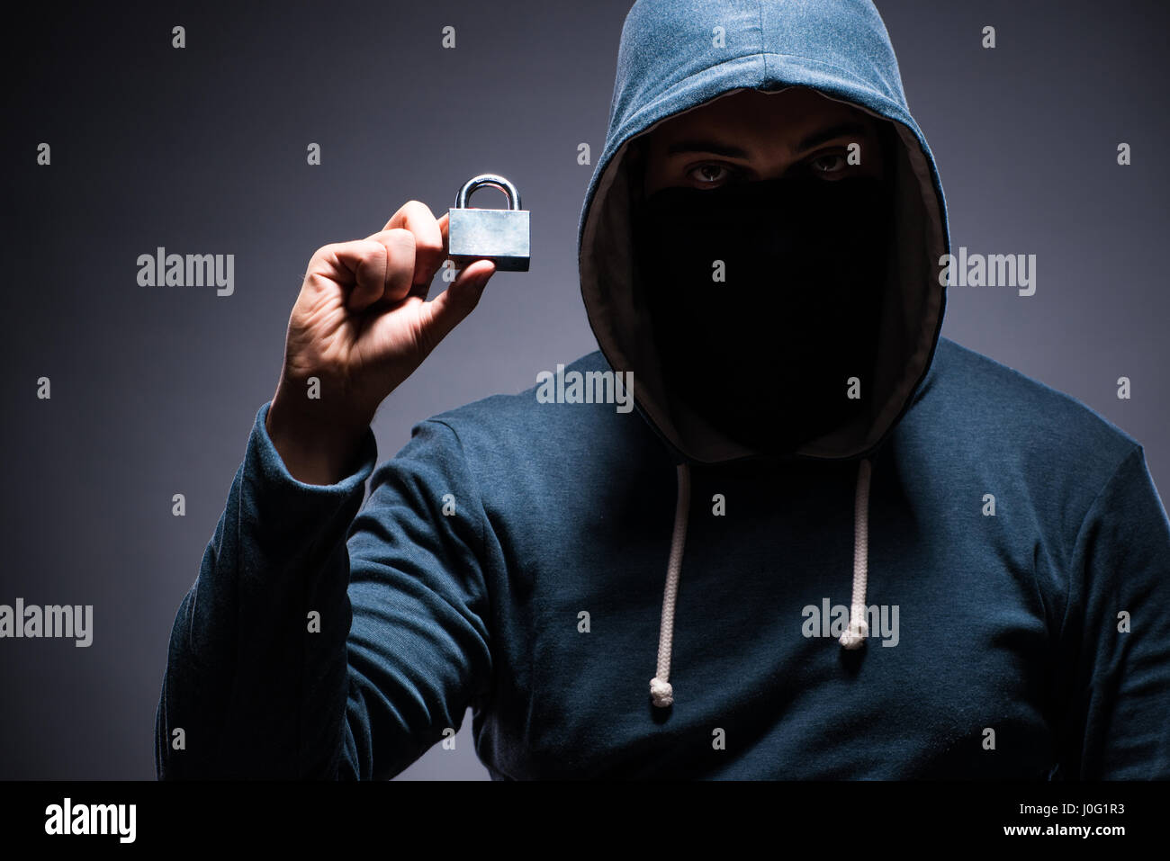 Hacker wearing hood in dark hi-res stock photography and images - Alamy