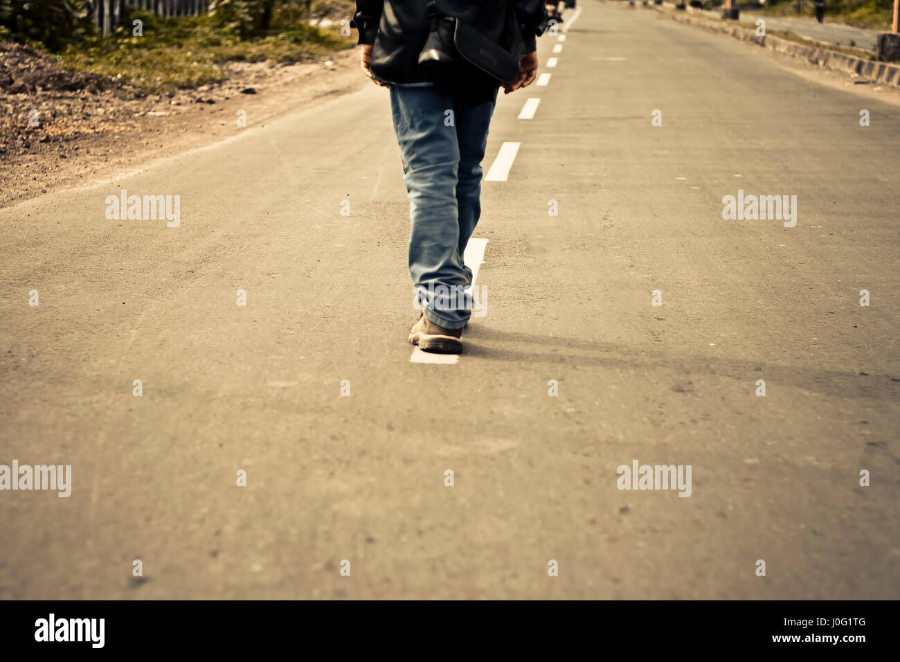 The road less travel. Human figure walking on the road and get two ...
