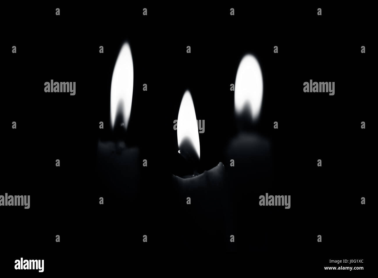 three different candles trying to end the darkness Stock Photo - Alamy