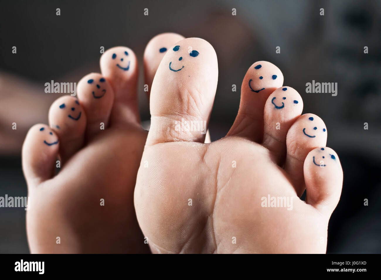 all ten toes of feet with smiley faces drawn with black pen Stock Photo ...