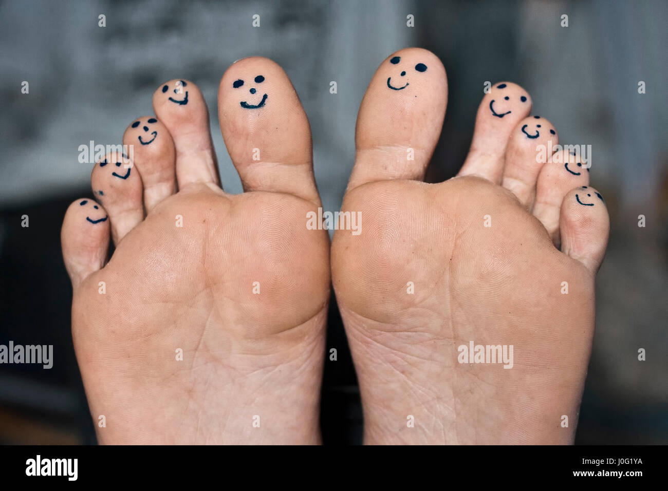 all ten toes of feet with smiley faces drawn with black pen Stock Photo ...