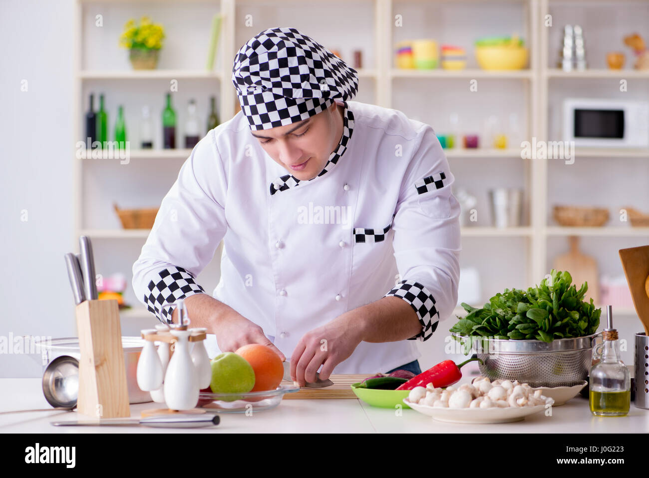 Young male cook working in the kitchen Stock Photo - Alamy