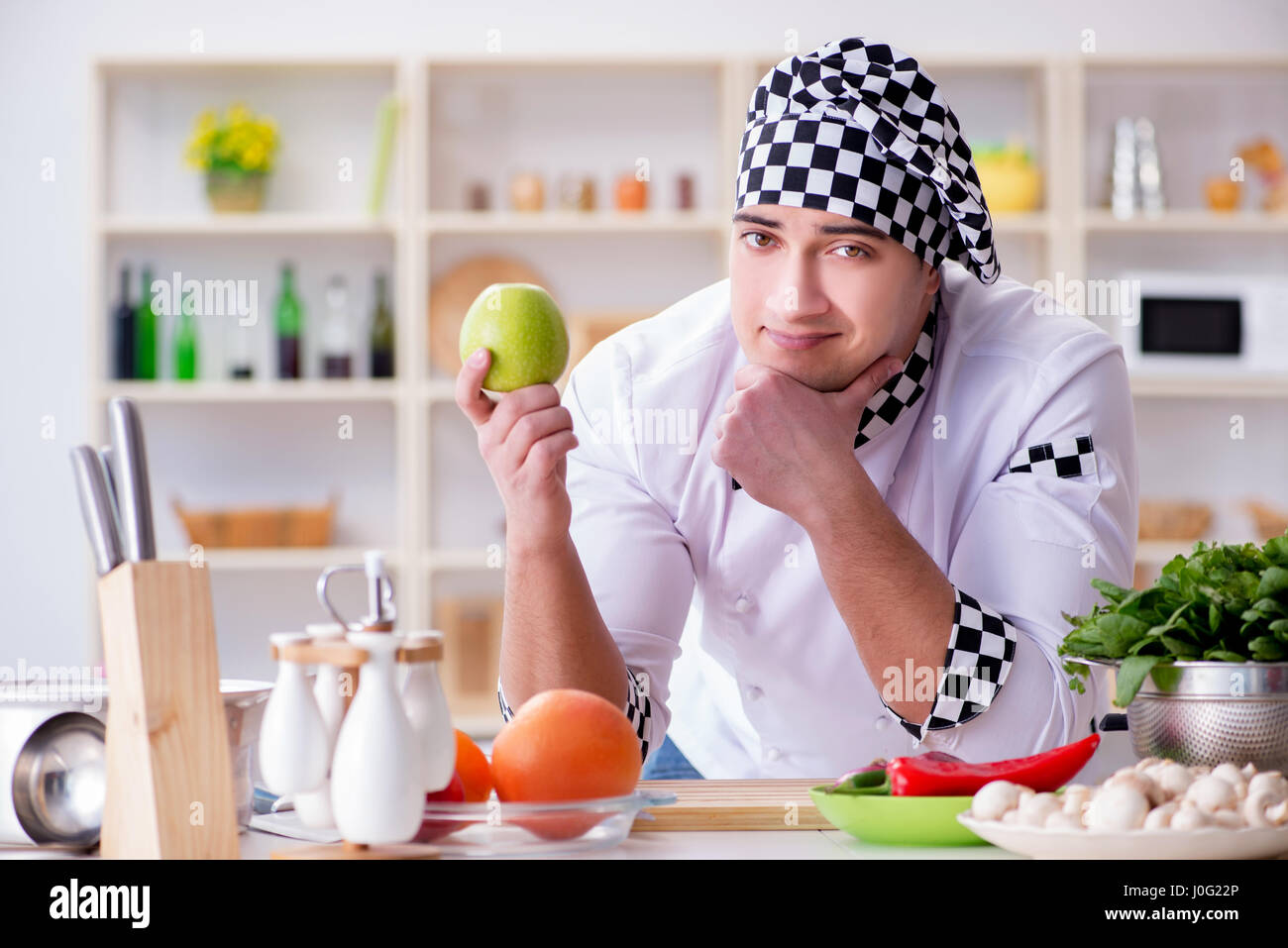 Young male cook working in the kitchen Stock Photo - Alamy