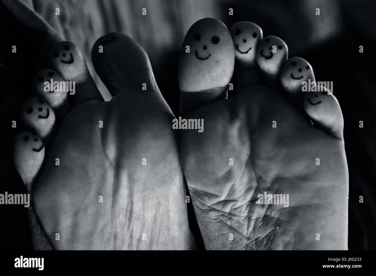 Smiley faces drawn on human foot with black pen Stock Photo - Alamy