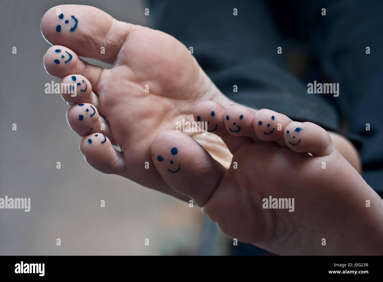 Smiley faces drawn on human foot with black pen Stock Photo - Alamy