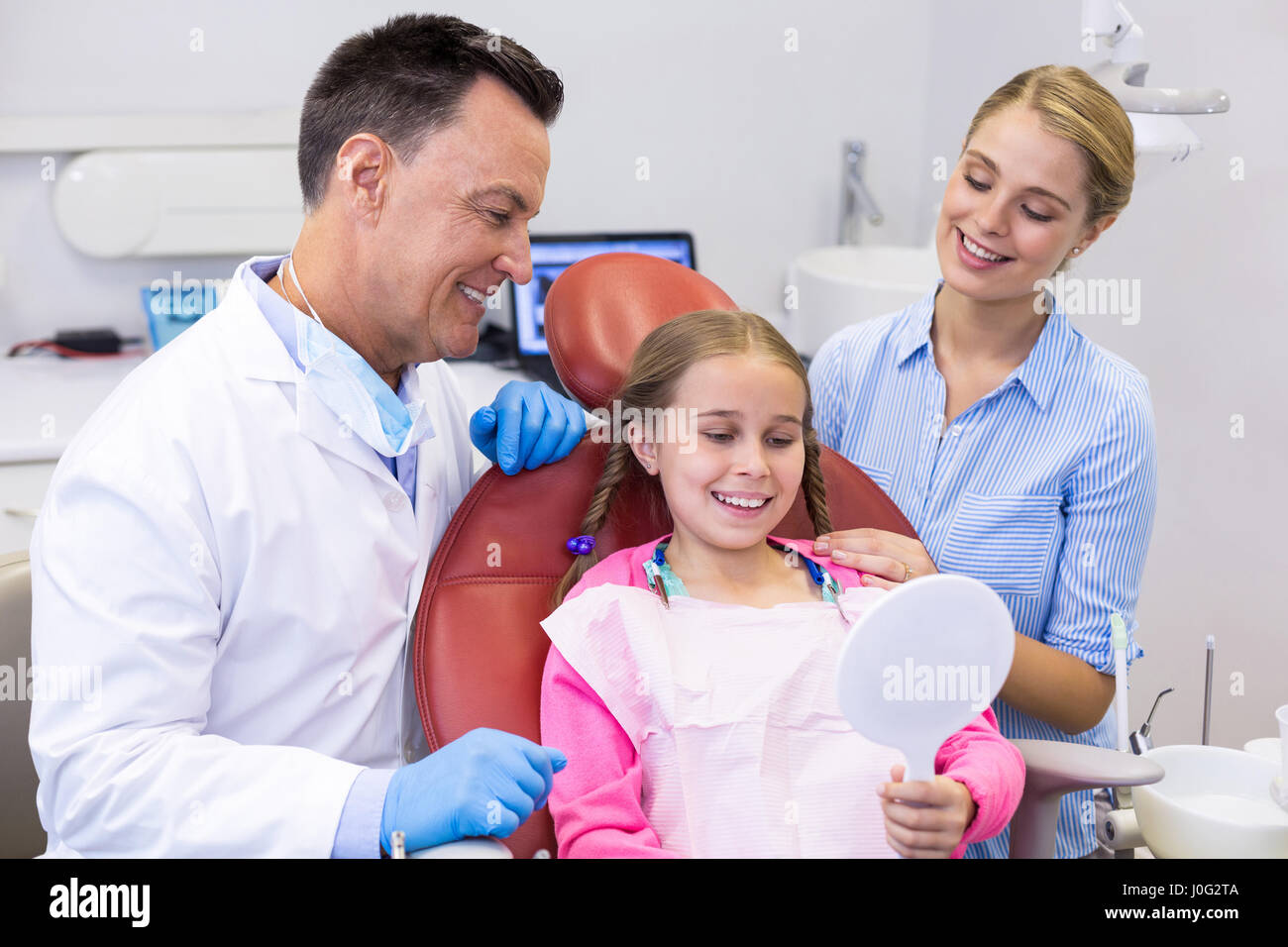Smiling Young patient looking at mirror in dental clinic Stock Photo ...