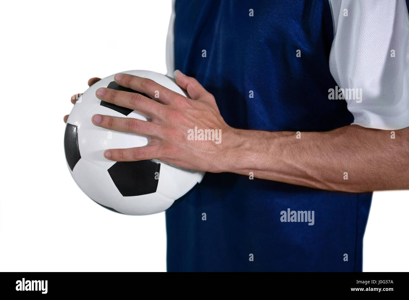 Mid-section of football player holding football with both hands against ...