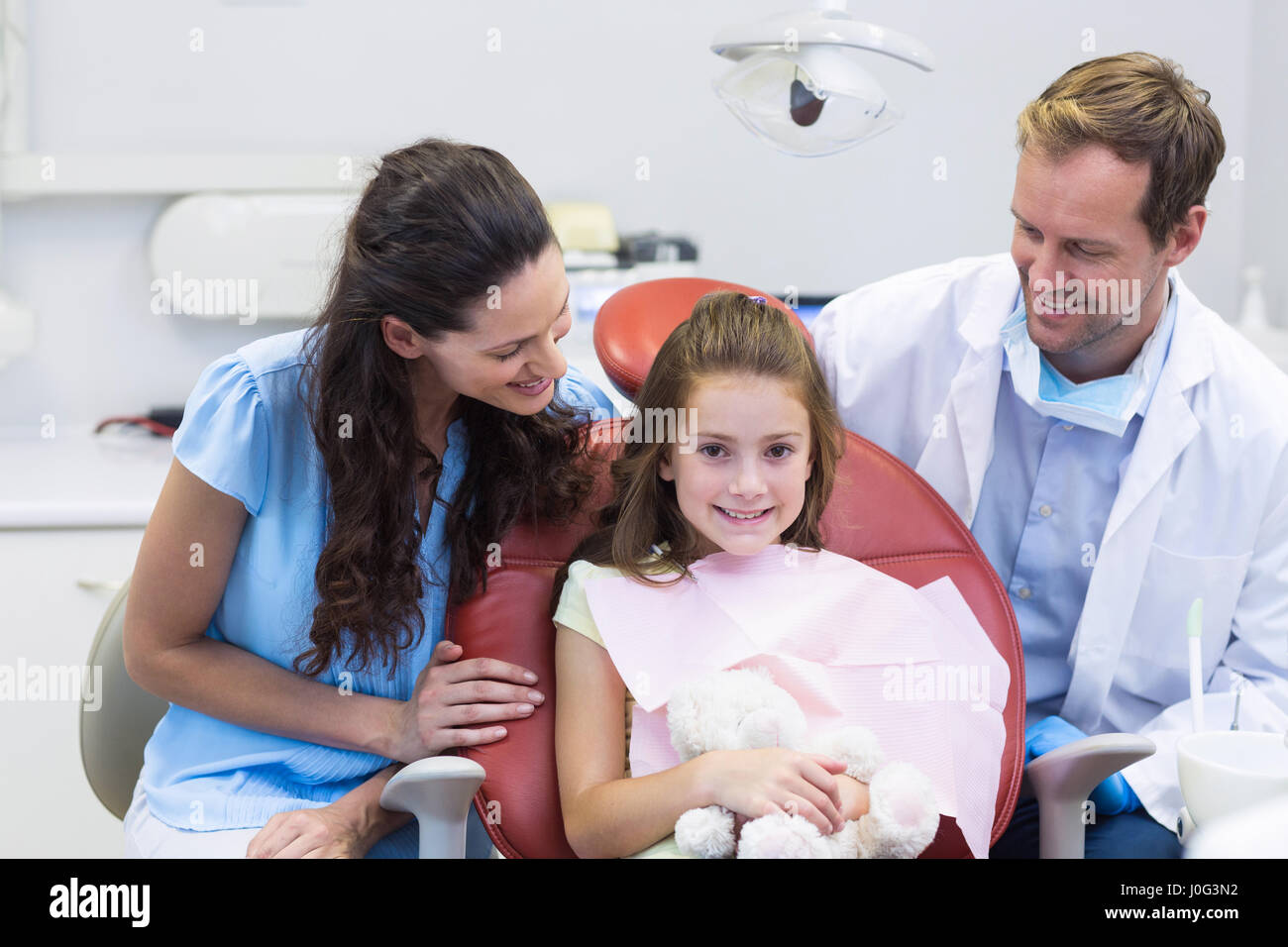 Mother interacting with daughter while dental examination at dental ...