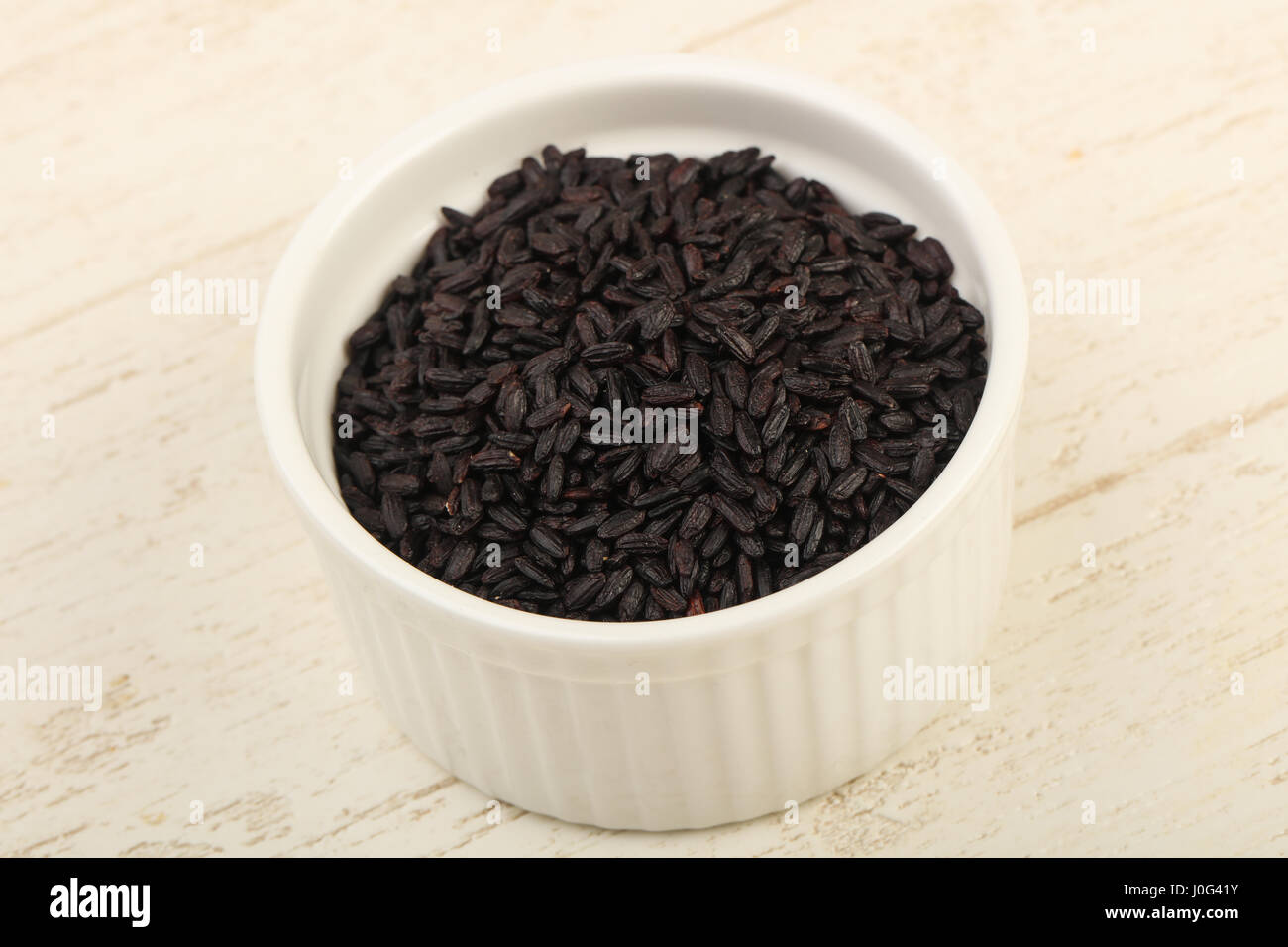 Black wild rice in the bowl over wooden background Stock Photo - Alamy