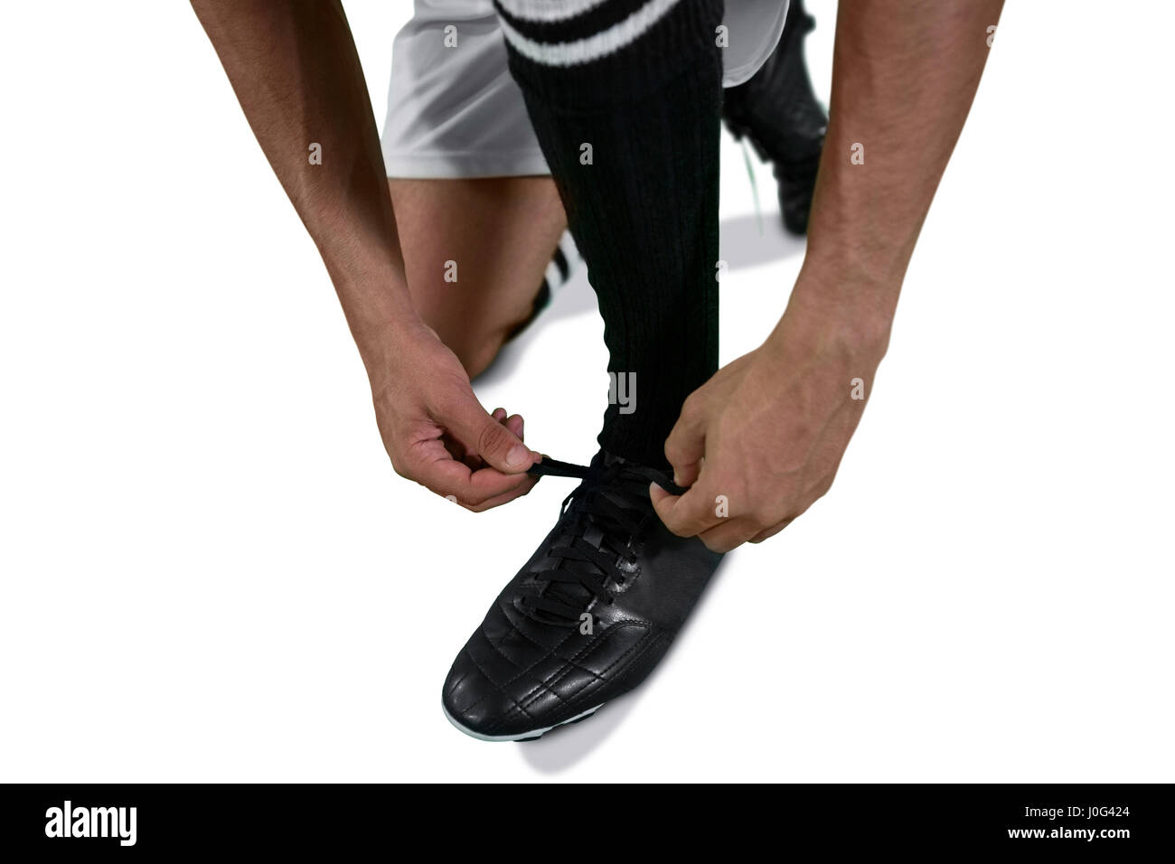 Football player tying his shoe lace on white background Stock Photo - Alamy
