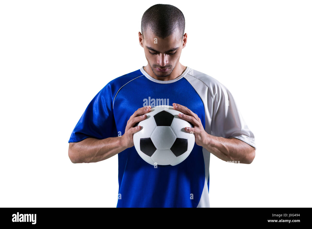 Football player holding football with both hands against white ...