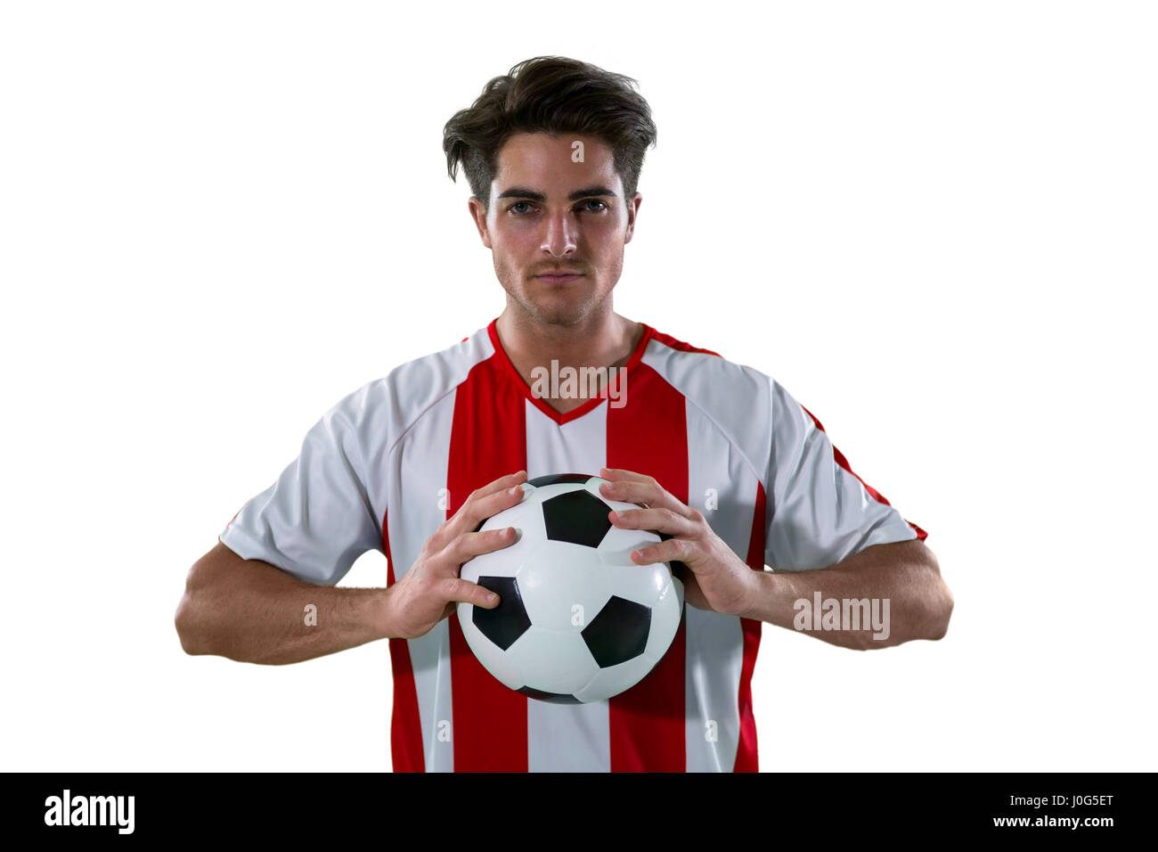 Football player holding football with both hands against white ...