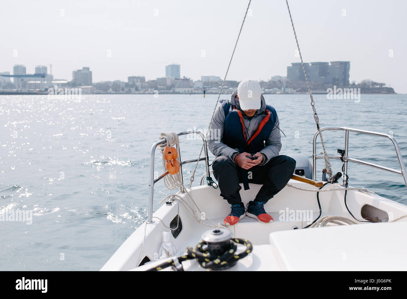 Man using a mobile phone on board a yacht Stock Photo - Alamy