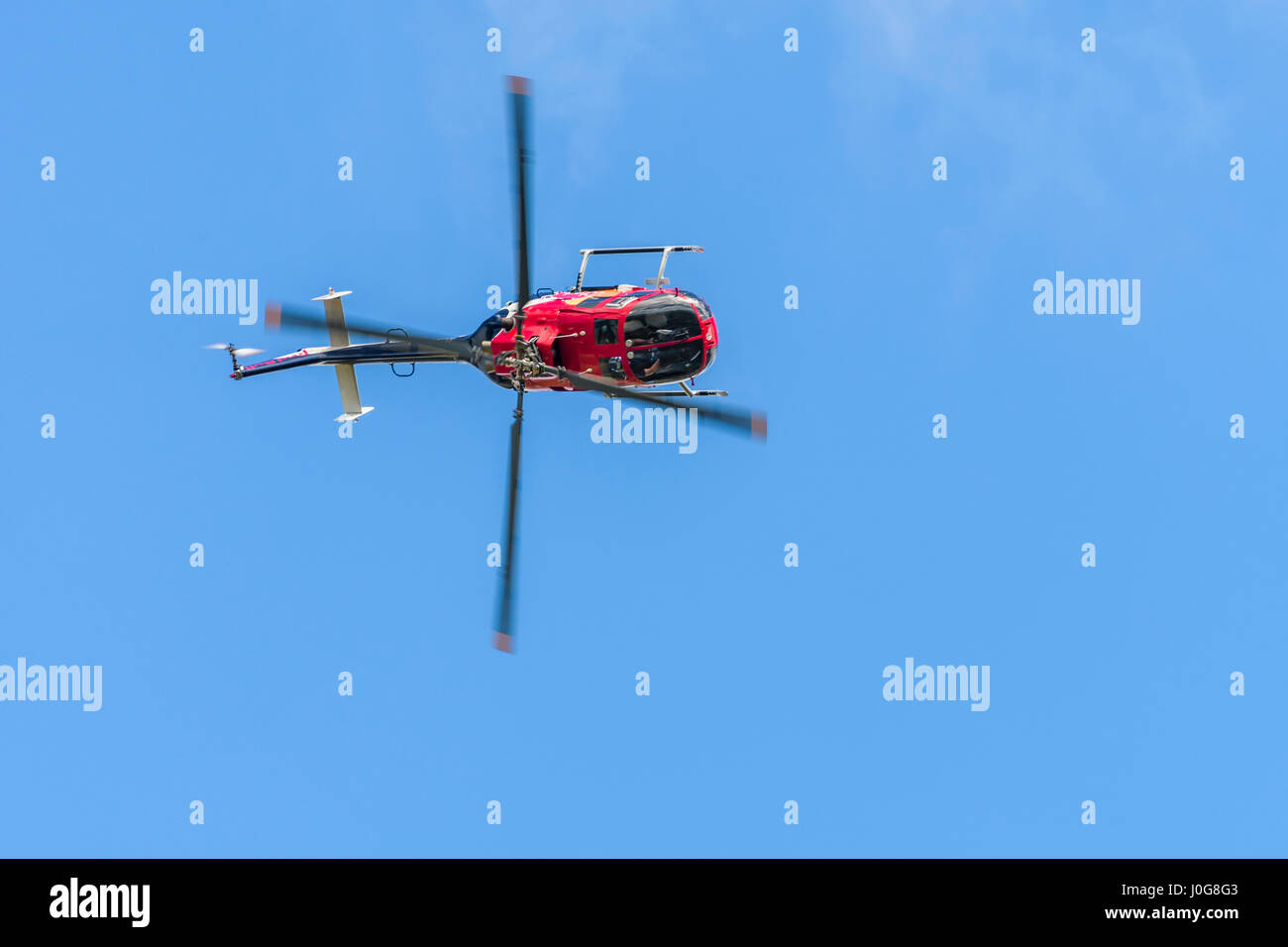Red helicopter in the air front view, facing towards viewer on plain ...