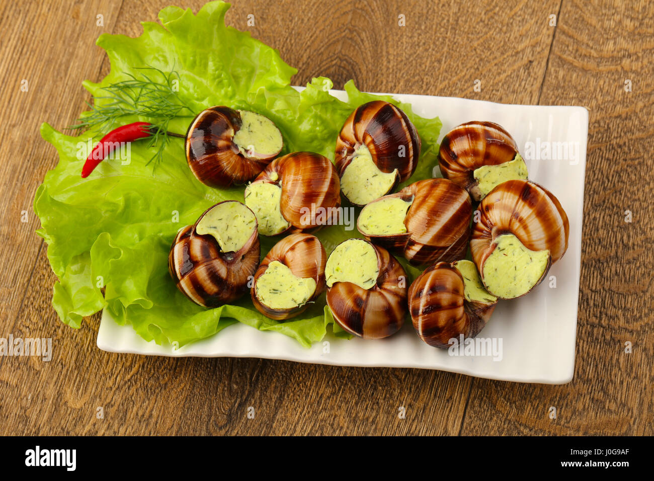 Escargot with cheese cream on salad leaves Stock Photo - Alamy