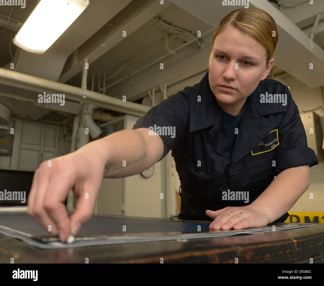 A Seaman prepares materials aboard the aircraft carrier USS Nimitz ...